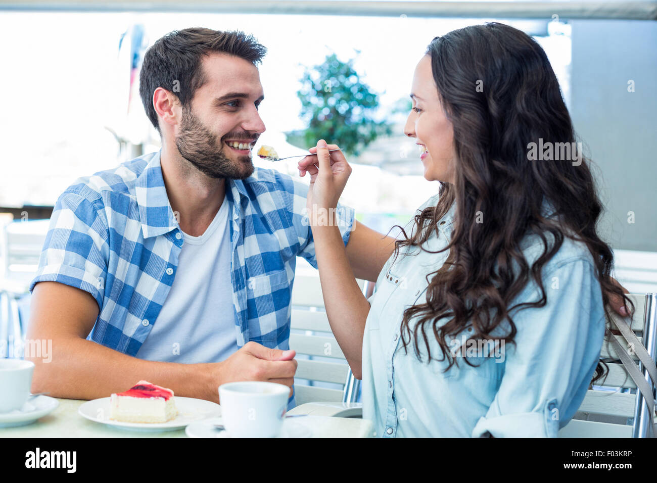 Young happy couple feeding each other with cake Stock Photo - Alamy