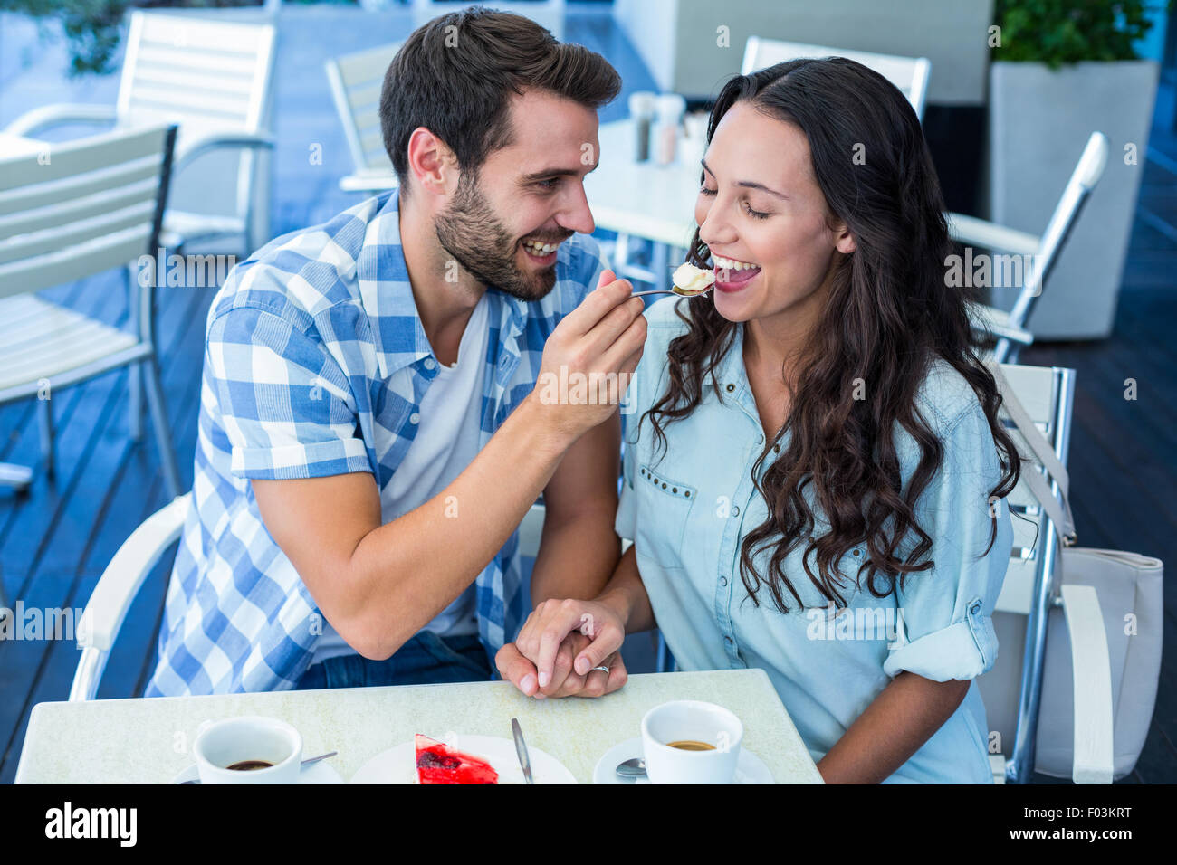 Young happy couple feeding each other with cake Stock Photo - Alamy