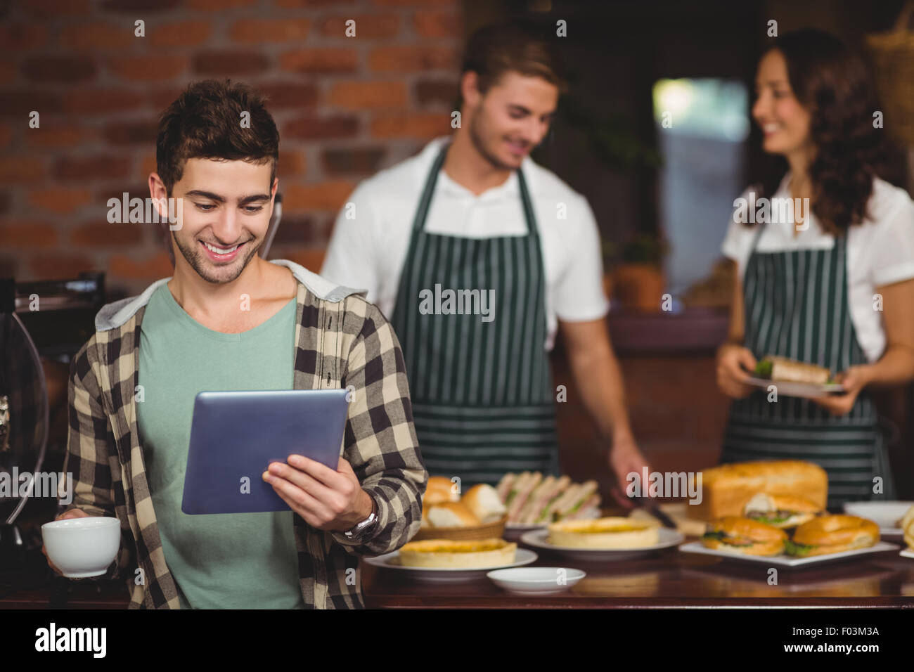 Smiling customer looking at tablet Stock Photo - Alamy