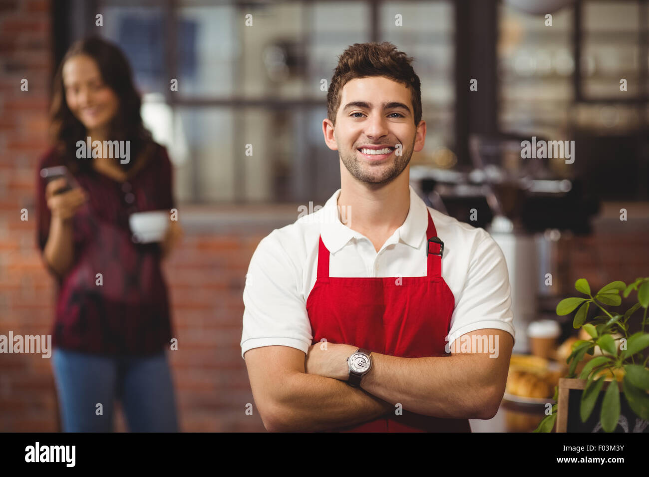 Handsome waiter with arms crossed Stock Photo - Alamy