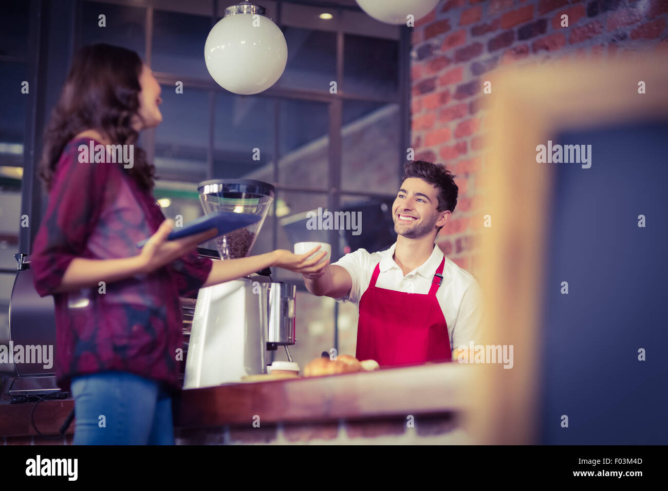 Smiling waiter serving a client Stock Photo - Alamy