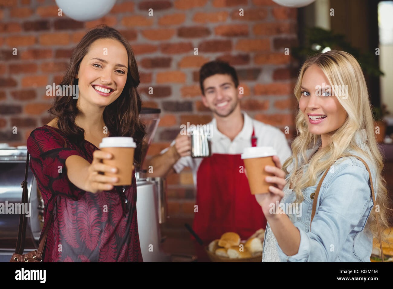 Smiling waiter and two customers looking at the camera Stock Photo - Alamy