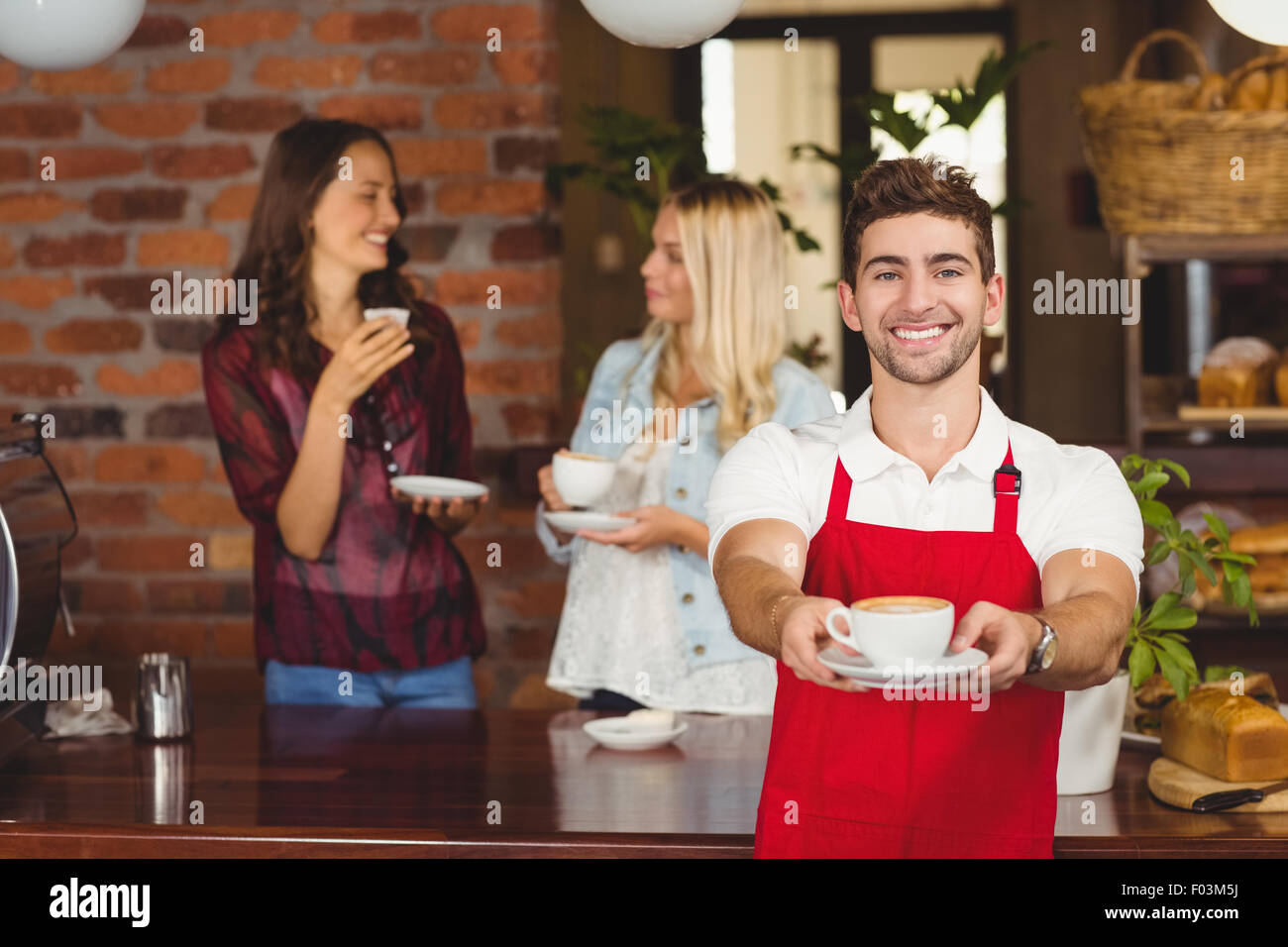 Handsome waiter handing a cup of coffee Stock Photo - Alamy