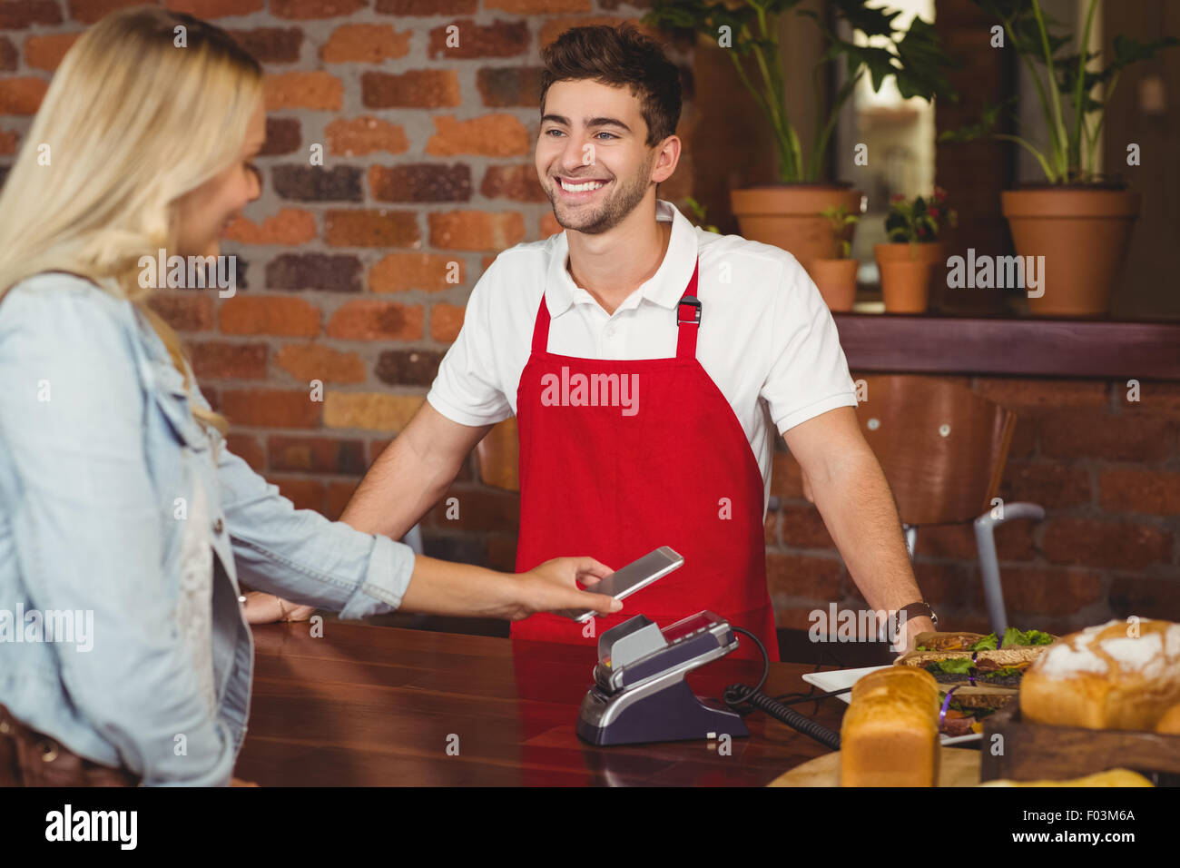 Pretty customer making a mobile payment Stock Photo - Alamy