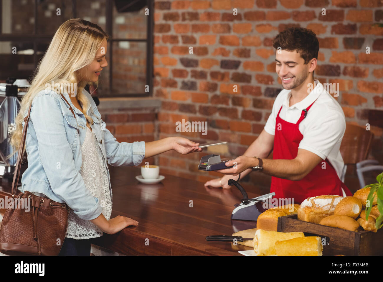 Pretty customer making a mobile payment Stock Photo - Alamy