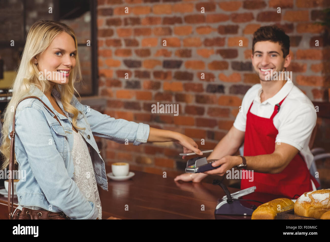 Pretty customer making a mobile payment Stock Photo - Alamy
