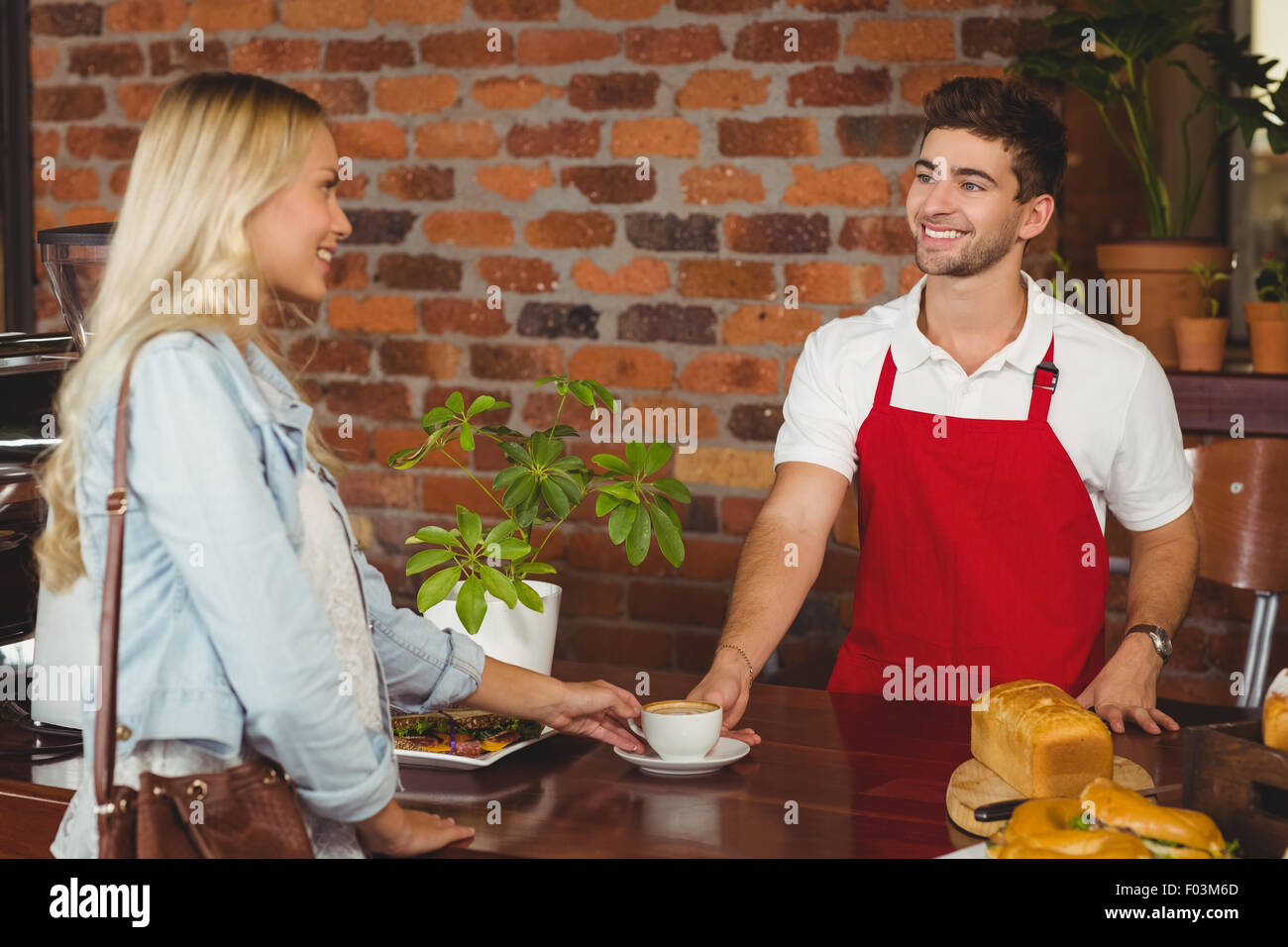 Smiling barista serving a client Stock Photo - Alamy