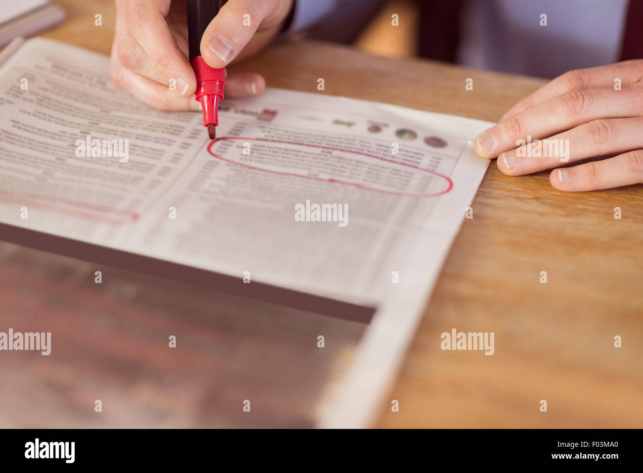 Businessman marking the newspaper with marker Stock Photo - Alamy