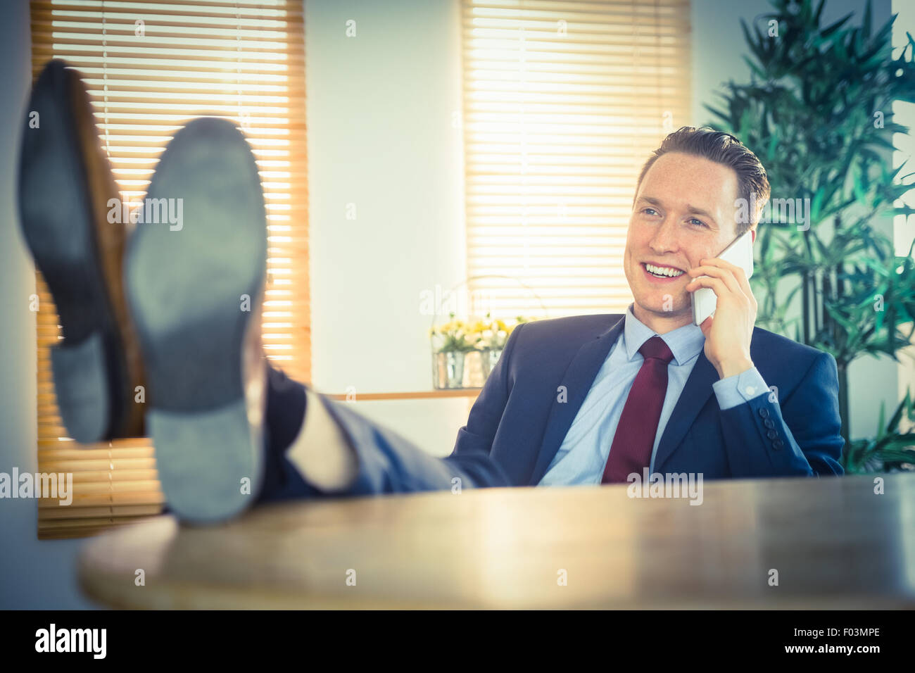 Relaxed businessman making a phone call Stock Photo - Alamy