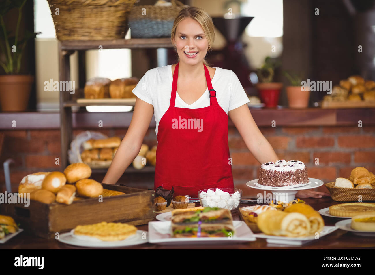 Pretty waitress bended over a food table Stock Photo - Alamy