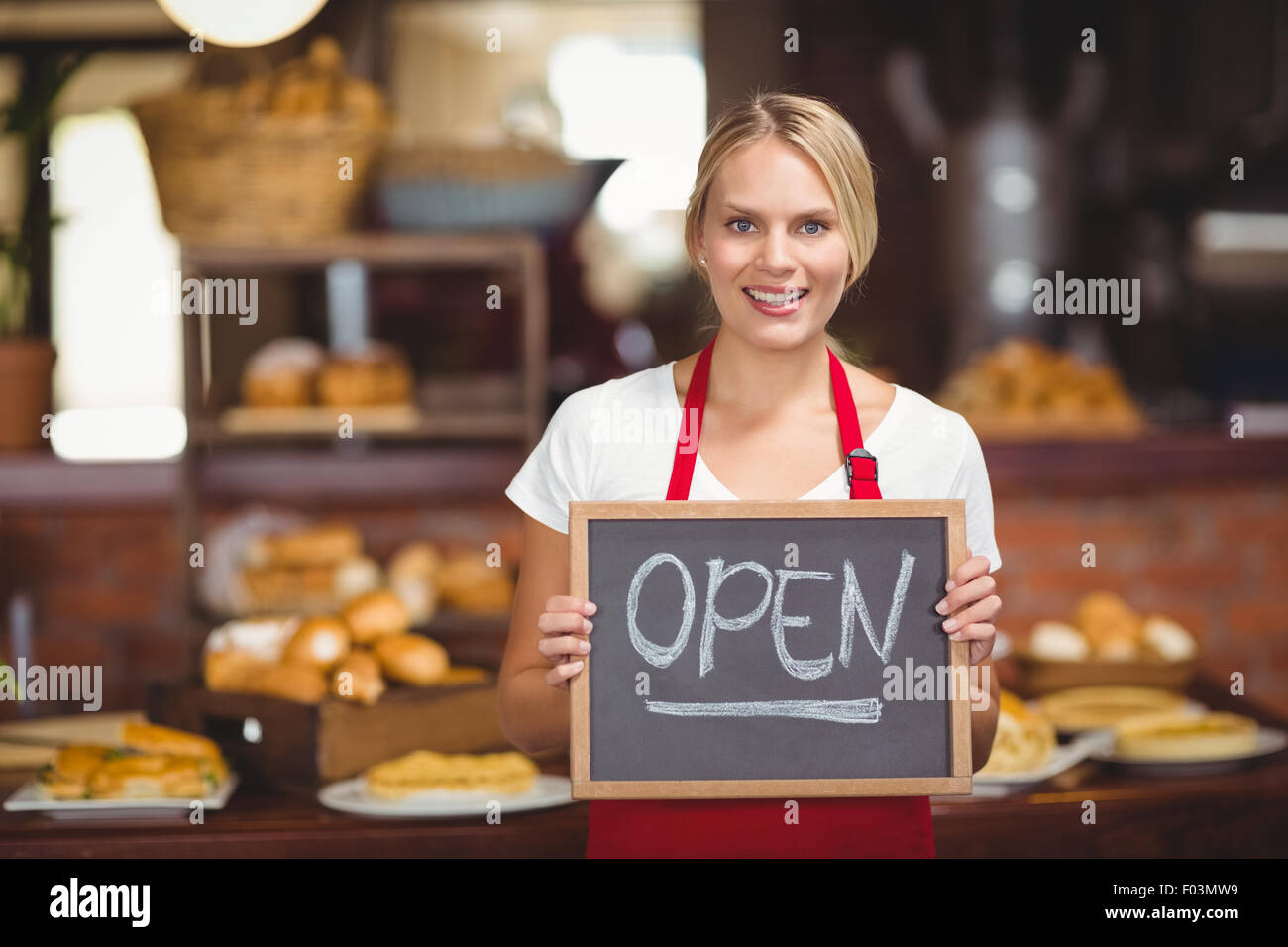 Pretty waitress with a chalkboard open sign Stock Photo - Alamy