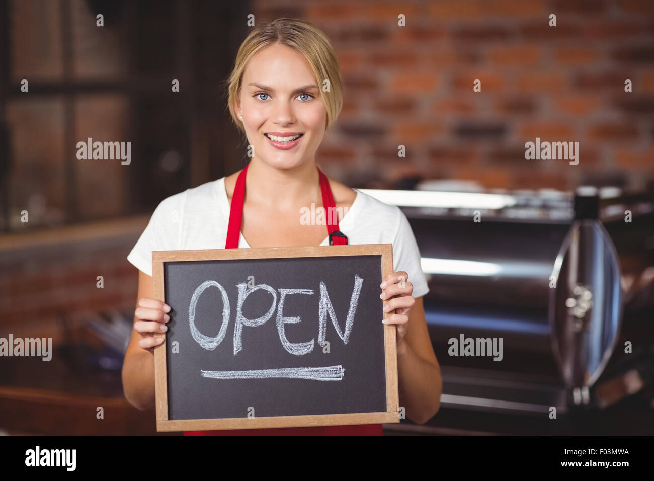 Pretty waitress with a chalkboard open sign Stock Photo - Alamy
