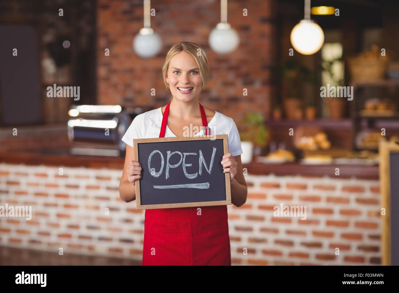 Pretty waitress with a chalkboard open sign Stock Photo - Alamy