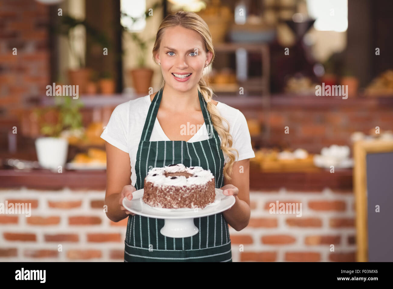 Pretty waitress holding a chocolate cake Stock Photo - Alamy