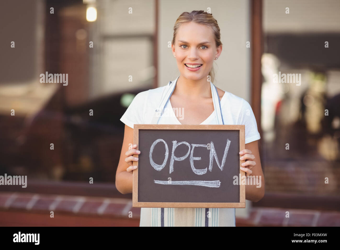 Waitress showing chalkboard open sign hi-res stock photography and ...