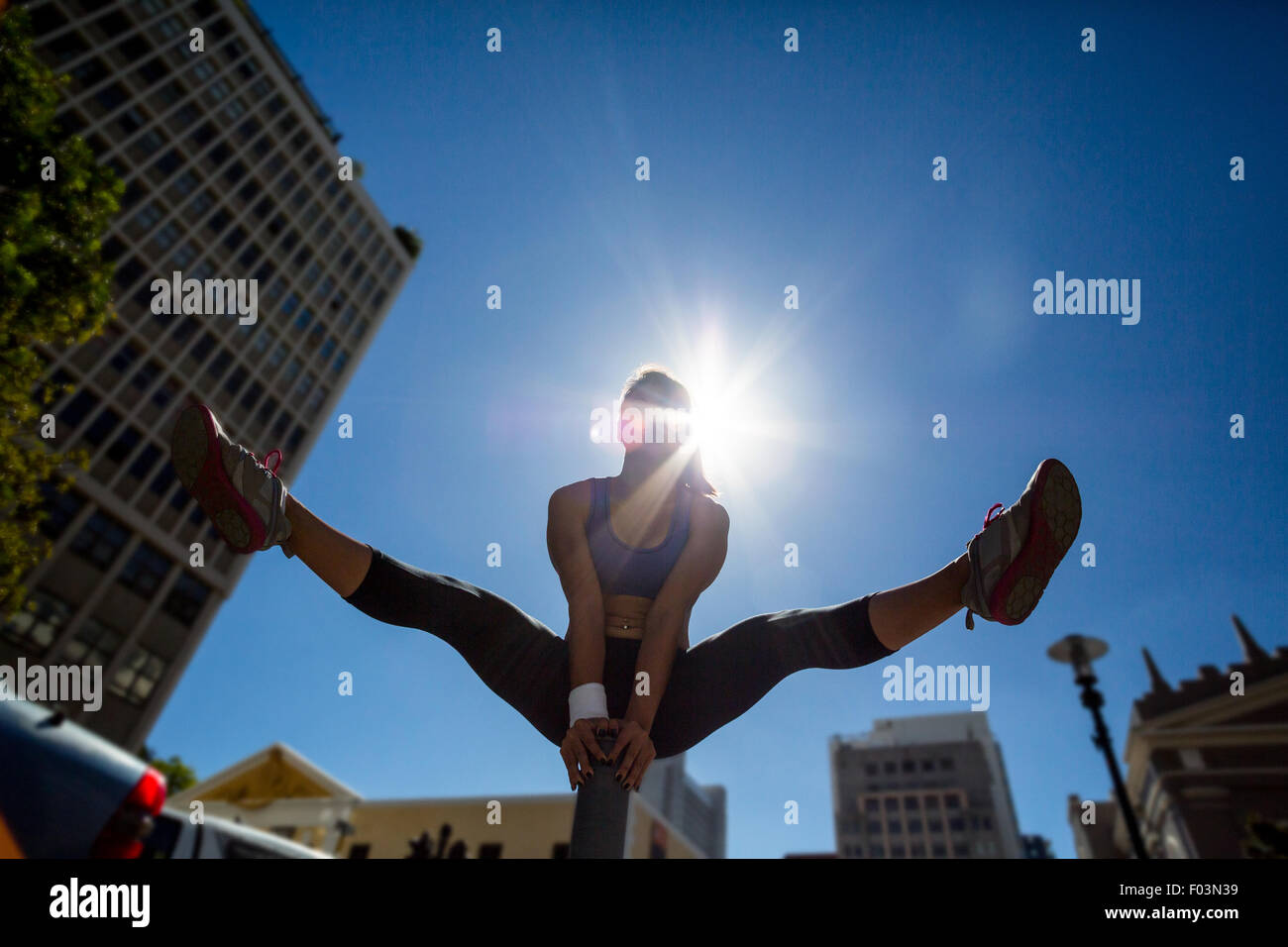 Athletic woman vaulting over bollard Stock Photo - Alamy