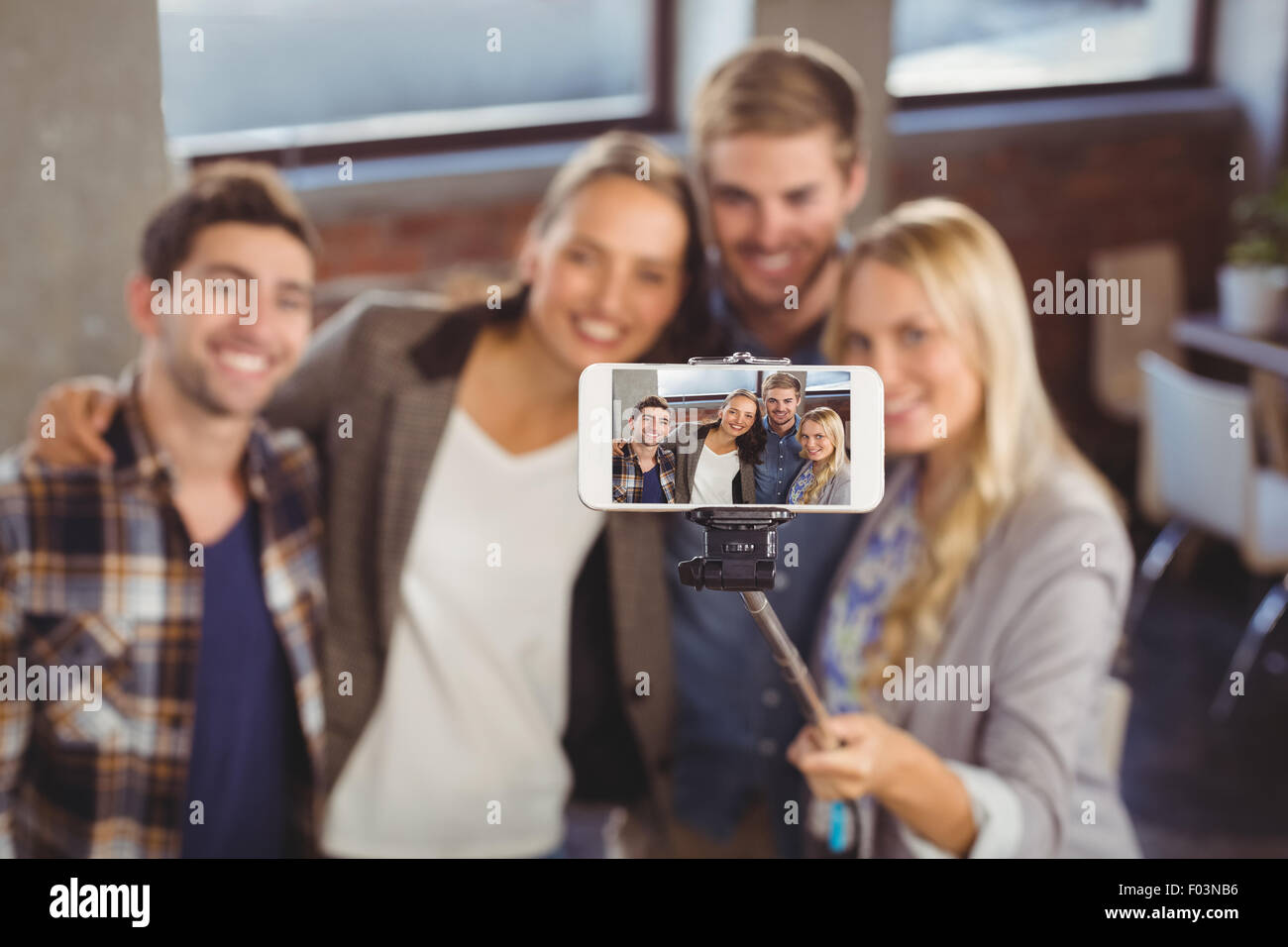 Smiling friends taking selfies with selfiestick Stock Photo - Alamy