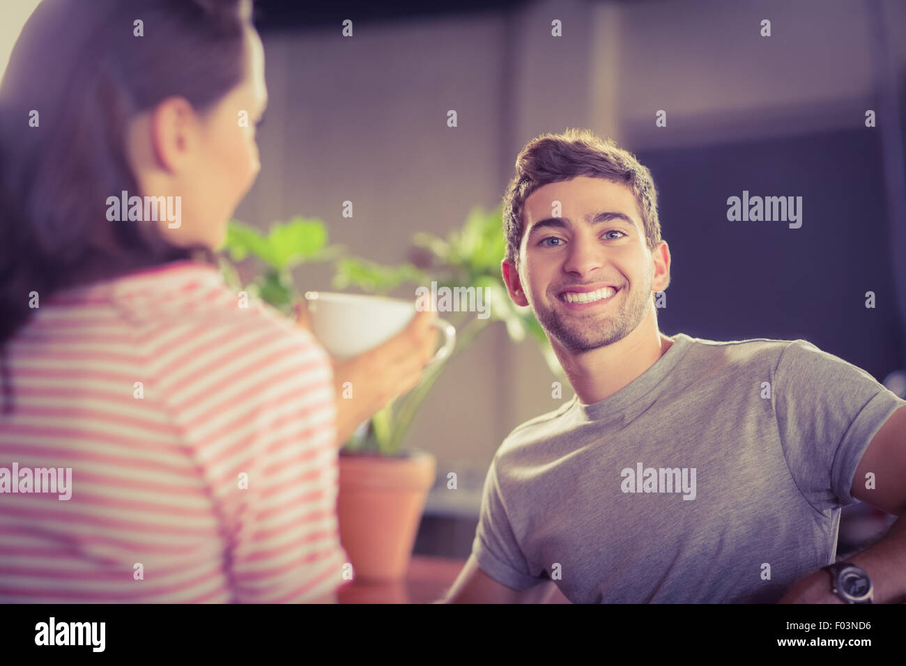 Smiling young man having coffee with his friend Stock Photo - Alamy