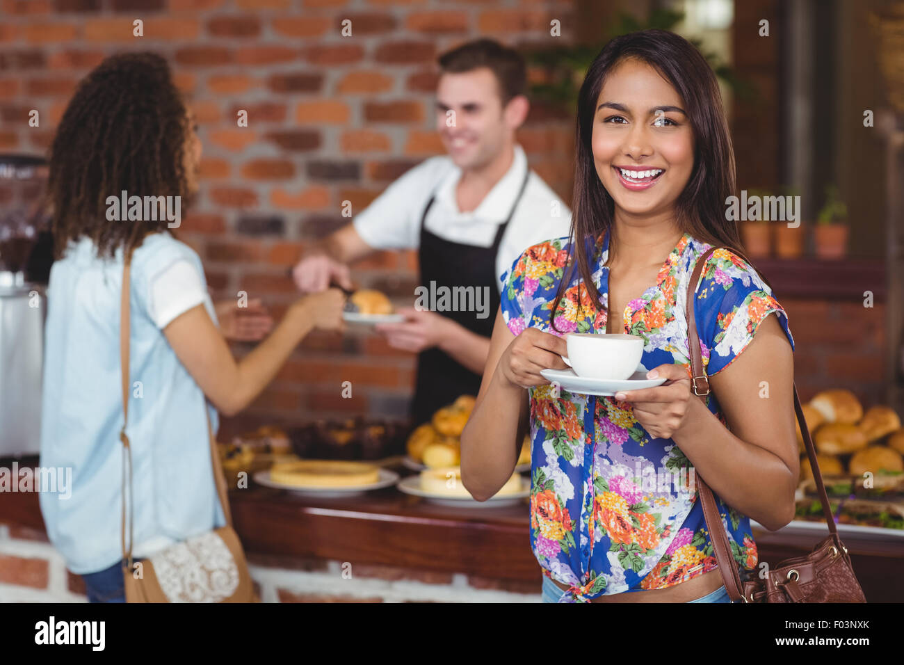 Smiling pretty customer holding cup of coffee Stock Photo - Alamy