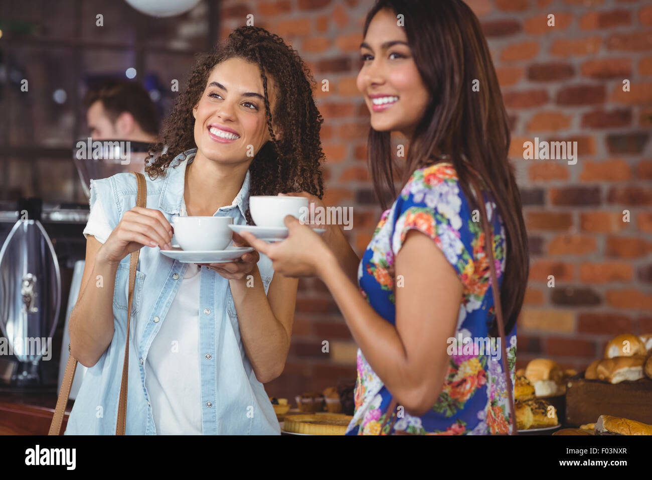 Smiling pretty customers with coffee cups Stock Photo - Alamy