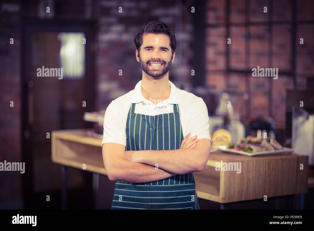 Smiling barista with arms crossed Stock Photo - Alamy