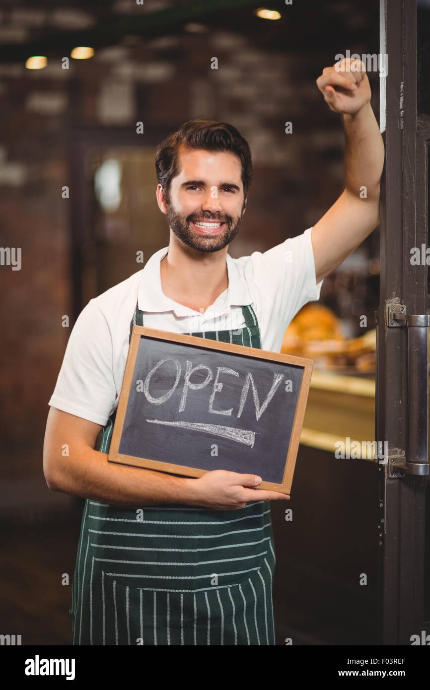 Smiling waiter showing chalkboard with open sign Stock Photo - Alamy