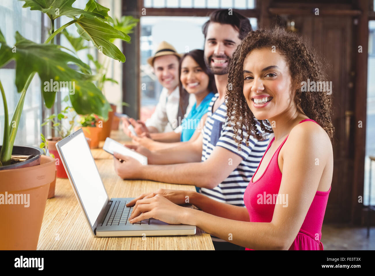 Happy friends using electronic devices Stock Photo - Alamy
