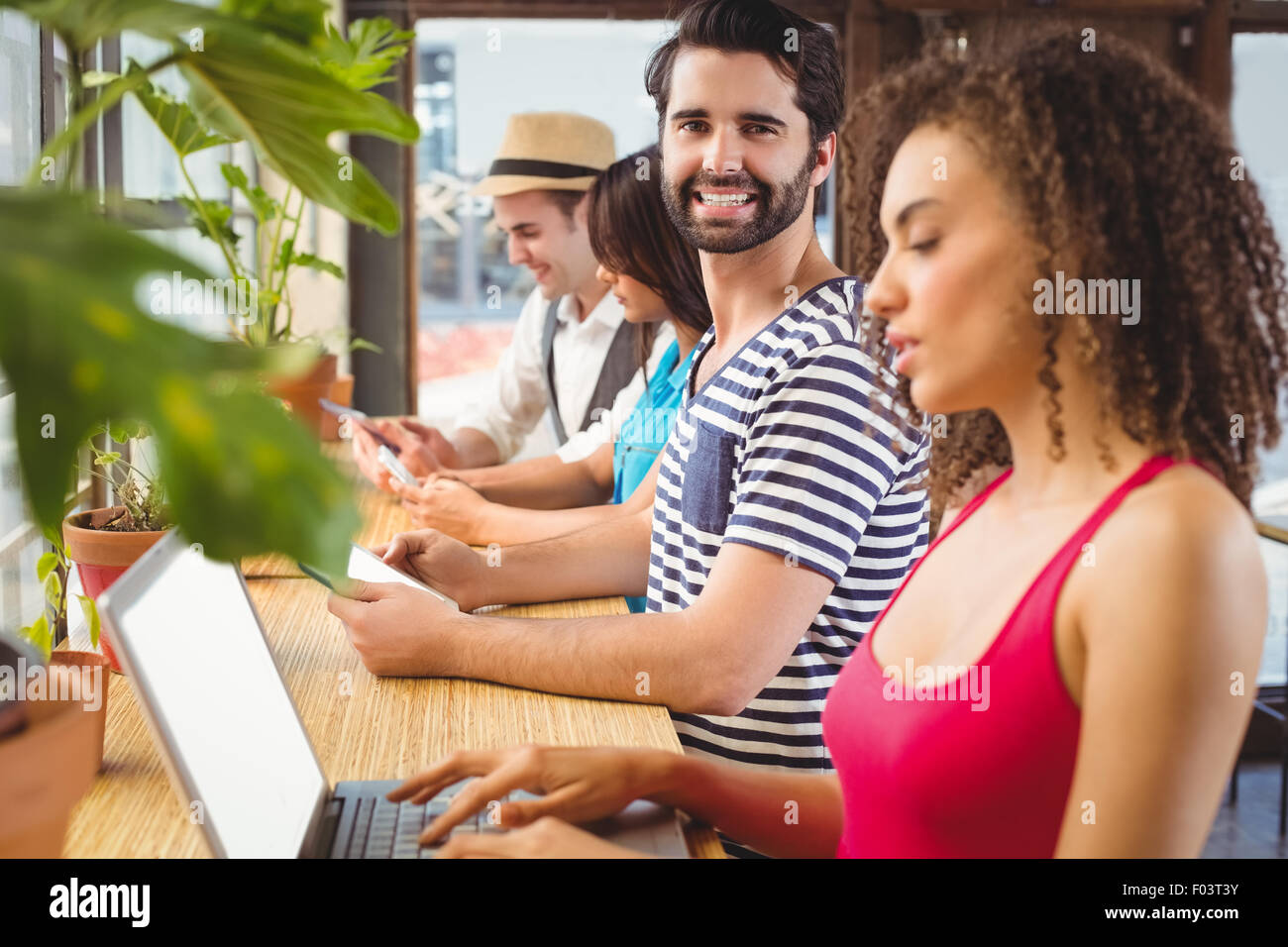 Happy friends using electronic devices Stock Photo - Alamy