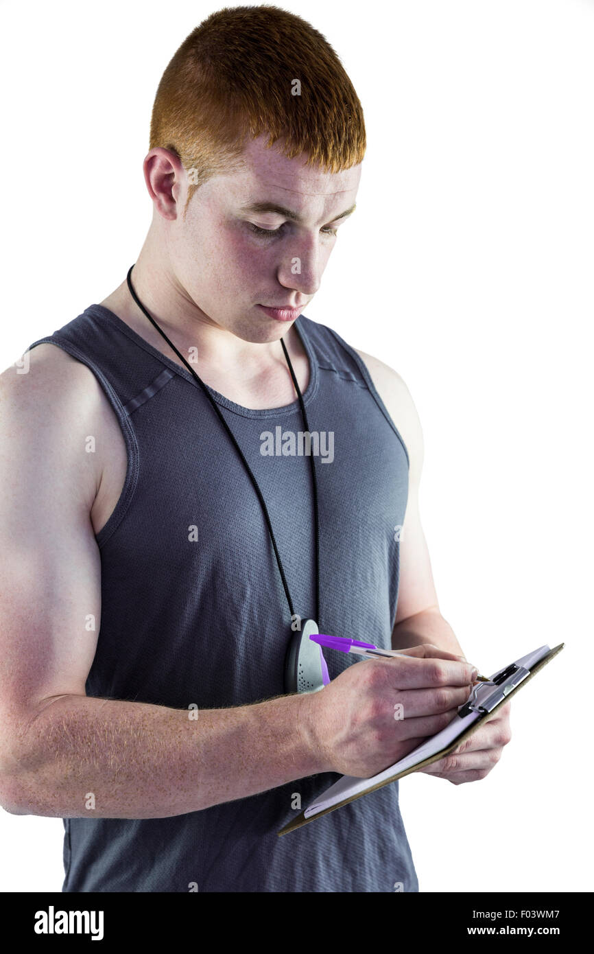 Fit personal trainer writing on clipboard Stock Photo - Alamy