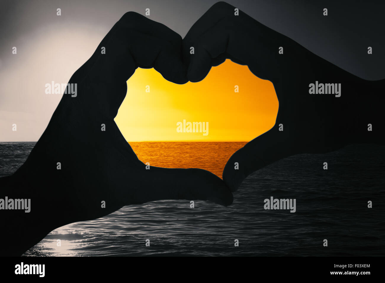 Composite image of couple making heart shape with hands Stock Photo - Alamy