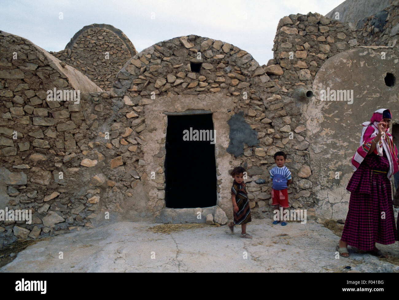 Woman and children in front of a house, El-Ferech, Tunisia Stock Photo ...