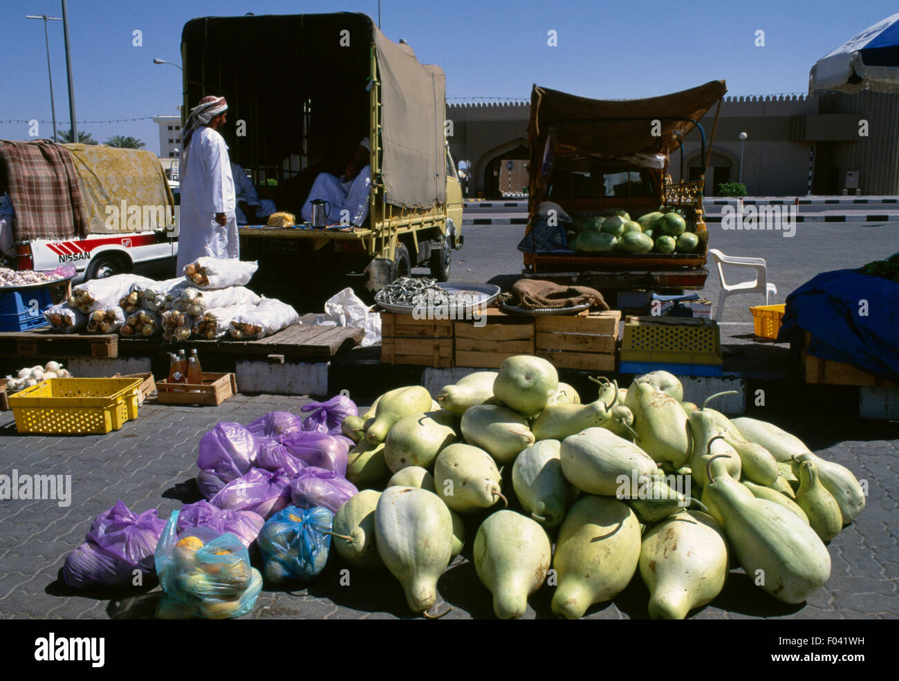 Market vendor setting up a pumpkin and vegetable stall, Al Ain, United ...