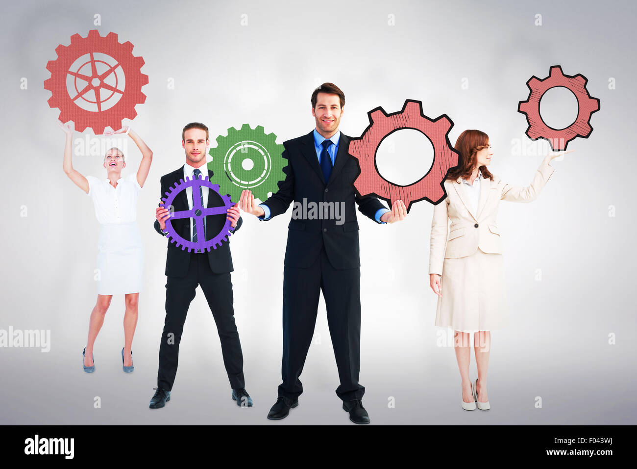 Composite image of business people holding cogs Stock Photo - Alamy
