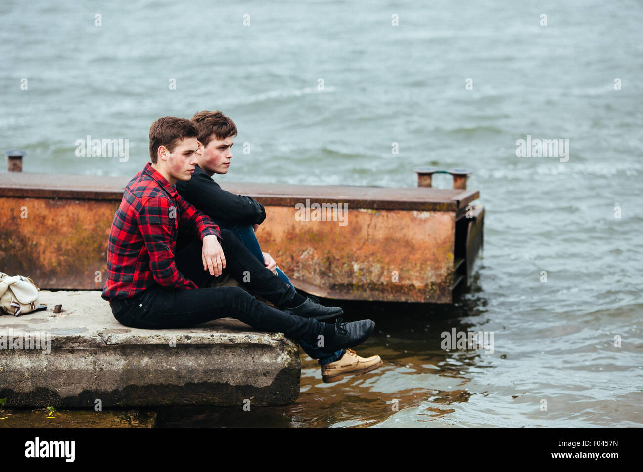 Two friends relaxing on the pier Stock Photo - Alamy