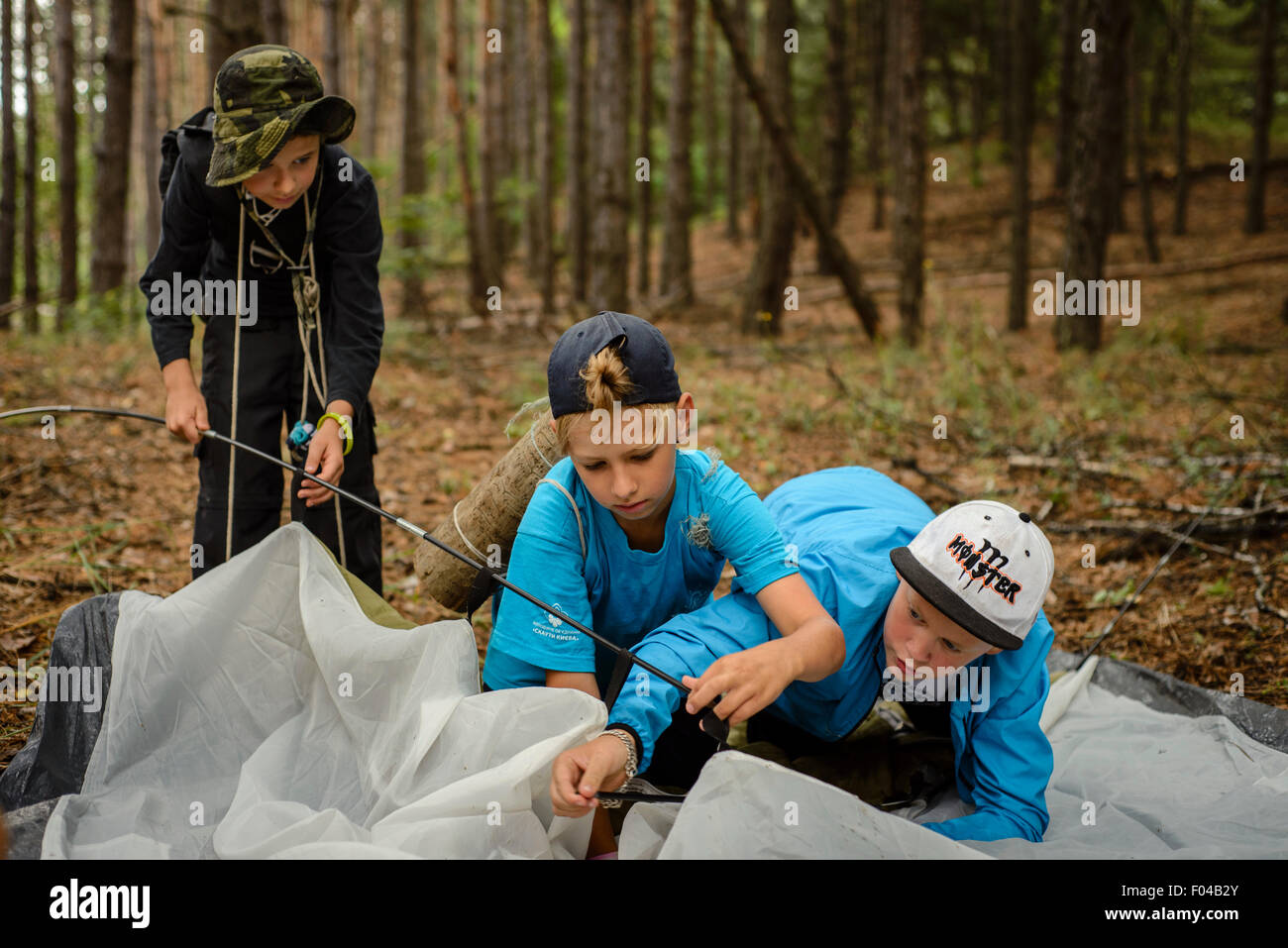 Boy scouts pitching a tent on a hike in Ukrainian scout training camp ...