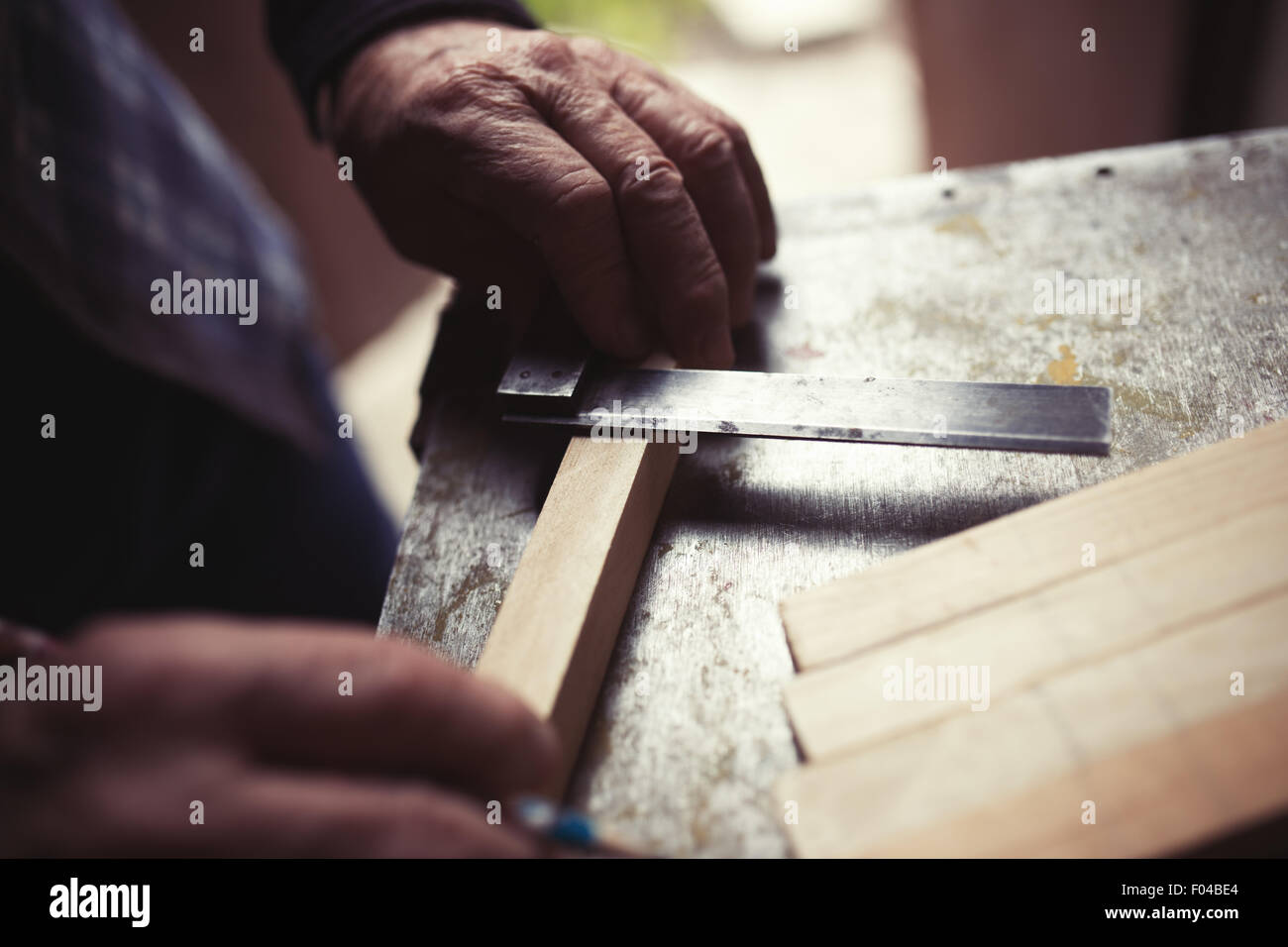 Old carpenter taking measurement of a wooden plank, retro tinted Stock ...