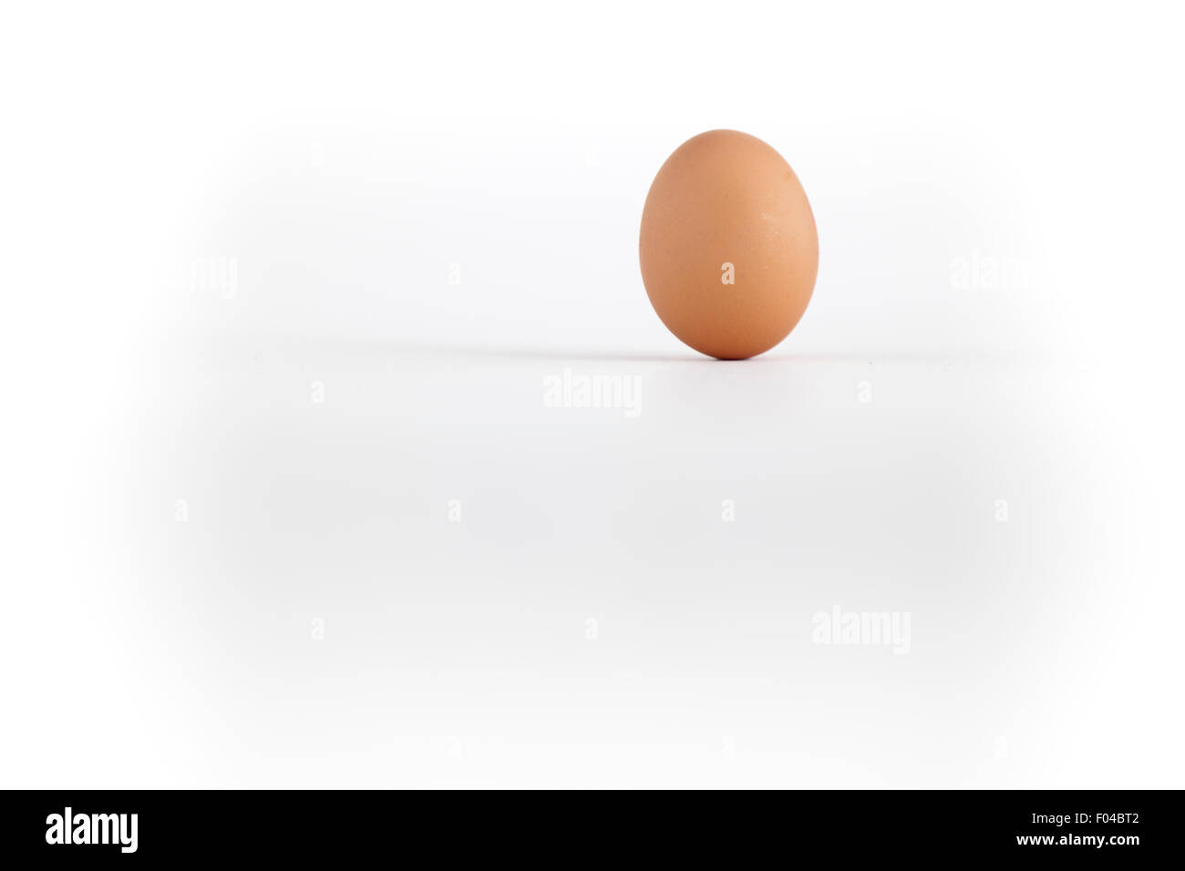 Egg balanced on a white background Stock Photo - Alamy