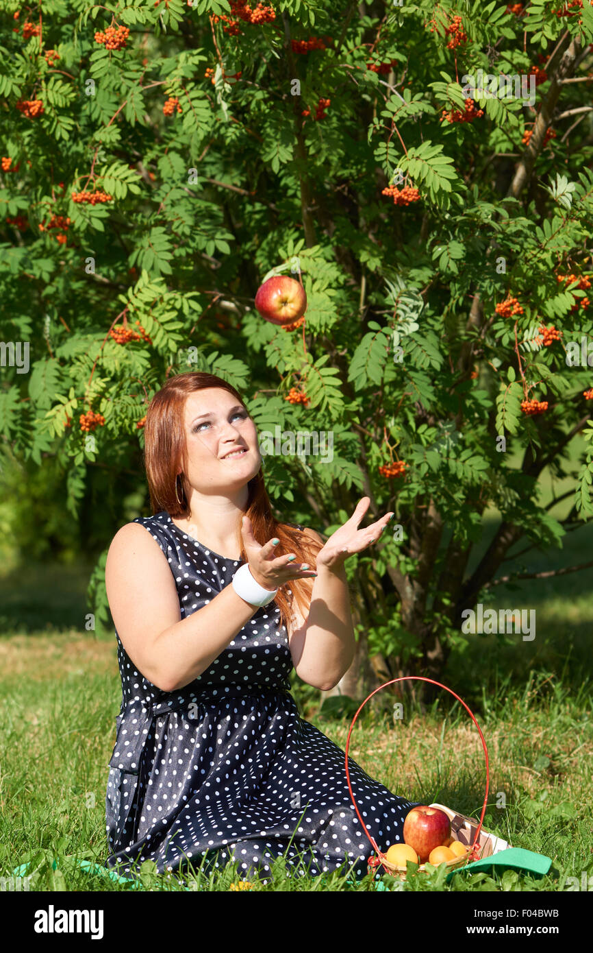 Girl throws up apple in the park at picnic Stock Photo - Alamy