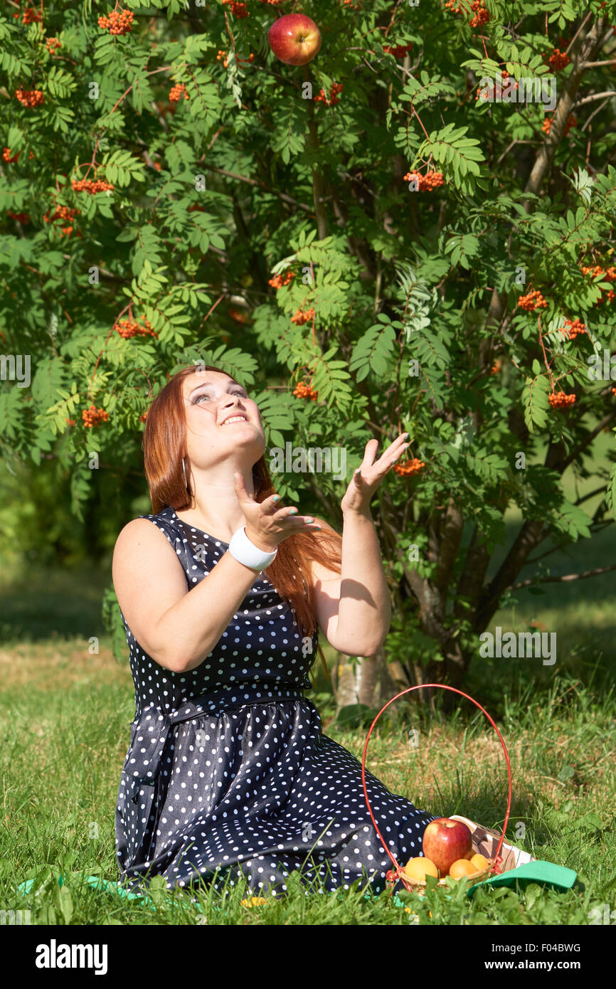 Happy girl has fun throwing up an apple Stock Photo - Alamy