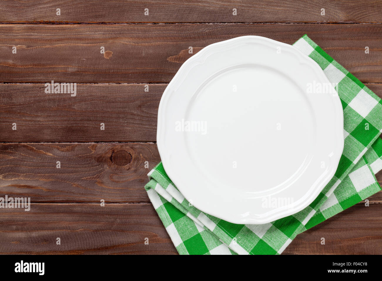 Empty plate over wooden table background. View from above with copy ...