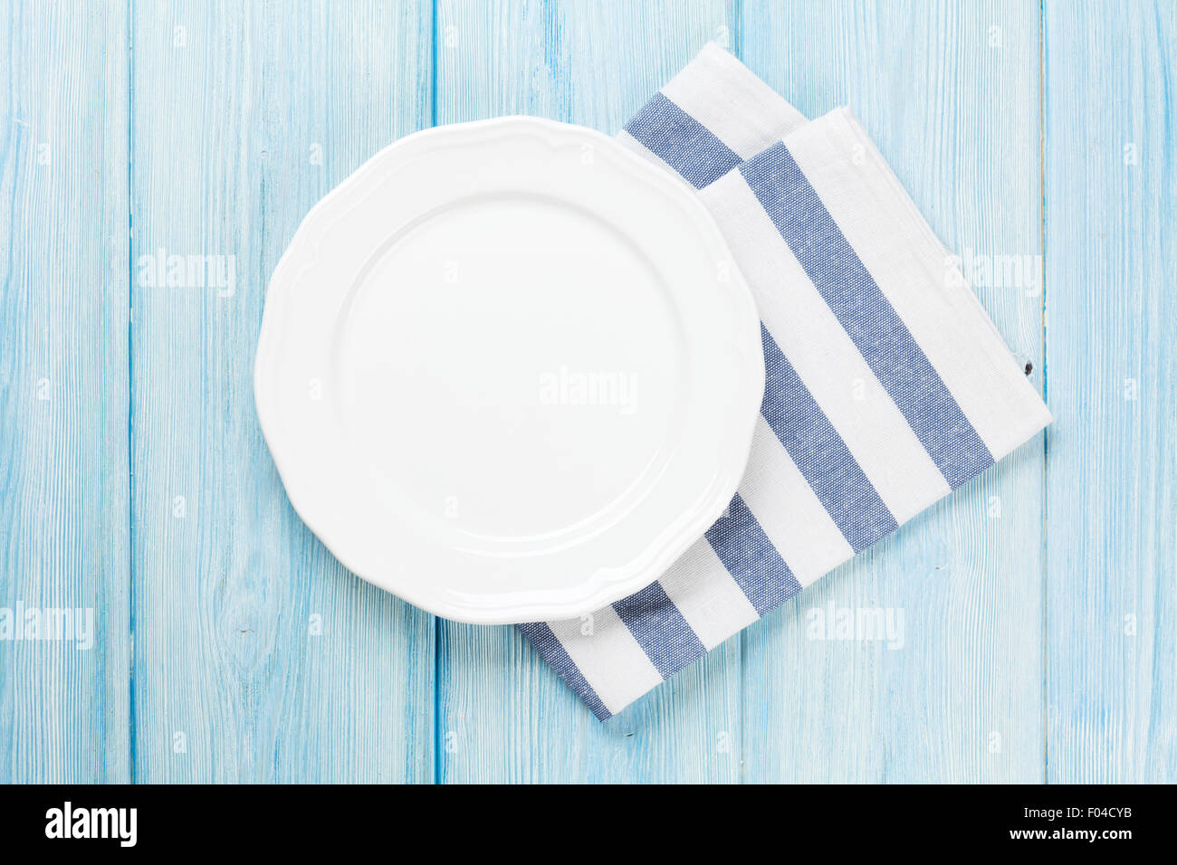 Empty plate over wooden table background. View from above with copy ...