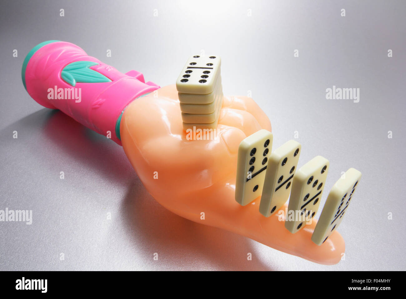 Plastic Hand with Dominoes Stock Photo - Alamy