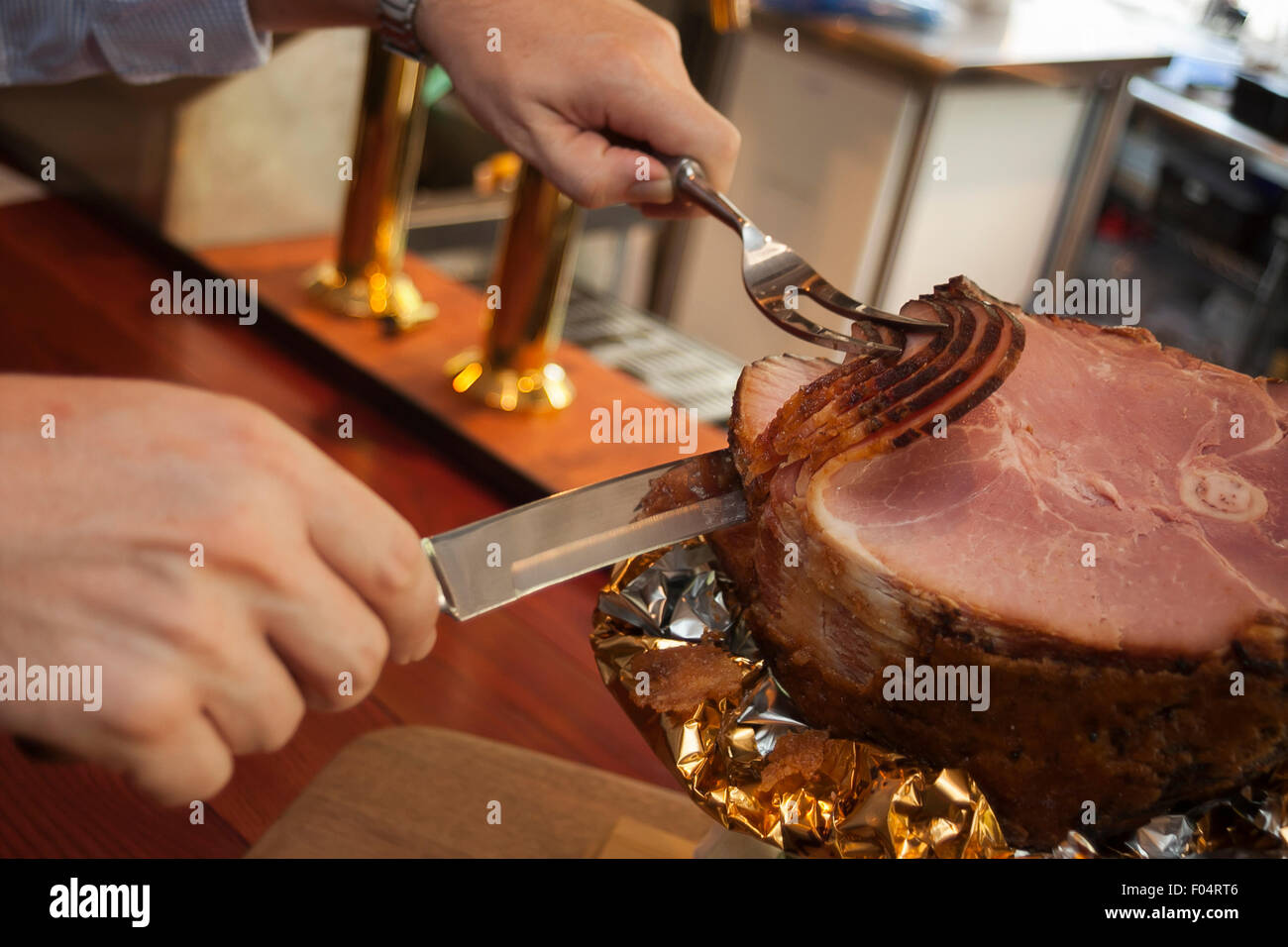 A member of staff slices a ''HoneyBaked Half Ham'' at the new Honey ...