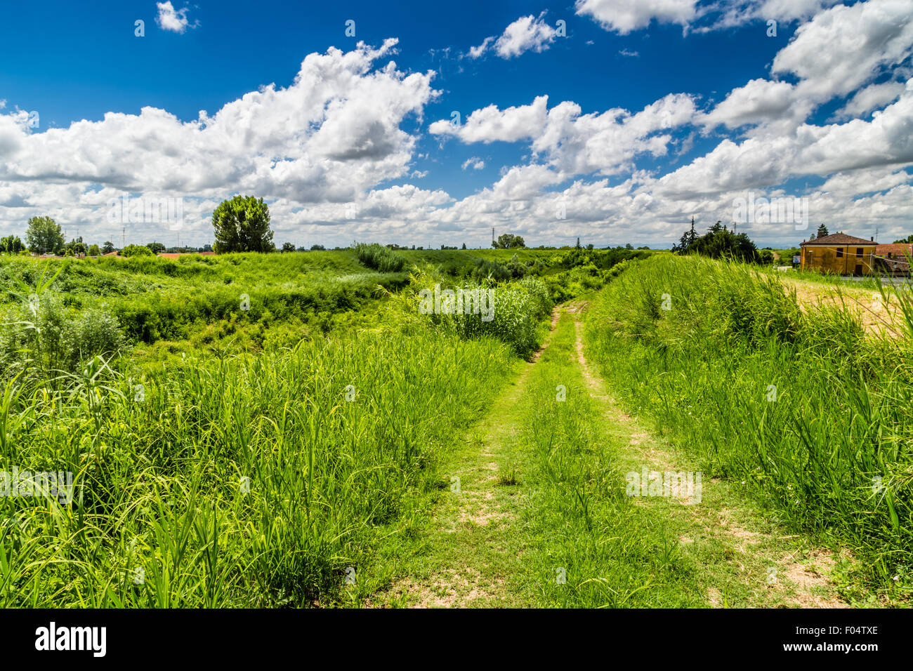 river in the countryside in the north of Italy under a cloudy blue sky ...
