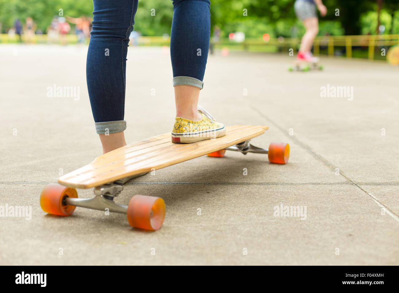Teenage girl practicing riding long board Stock Photo - Alamy