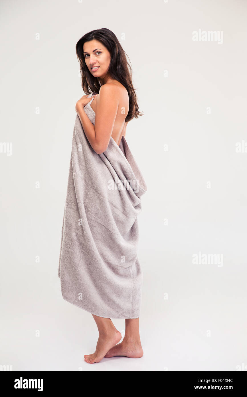 Full length portrait of a happy woman standing in towel isolated on a ...