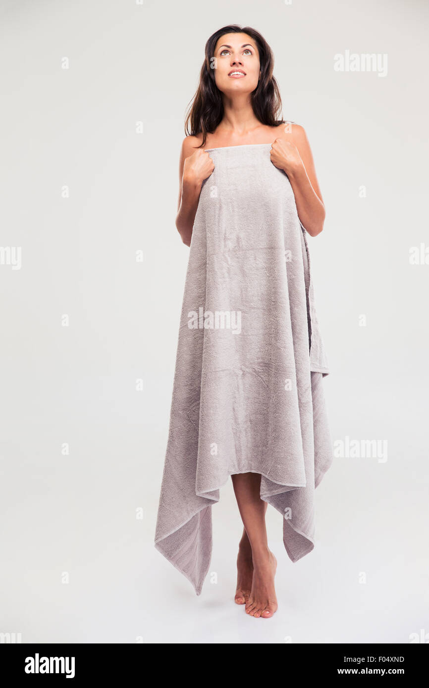 Full length portrait of a thoughtful woman standing in towel isolated ...