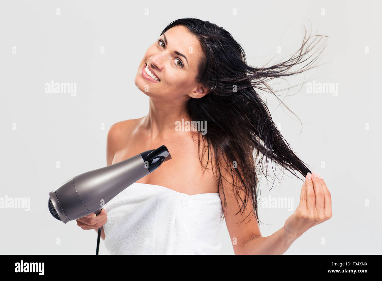 Smiling cute woman in towel drying her hair isolated on a white ...