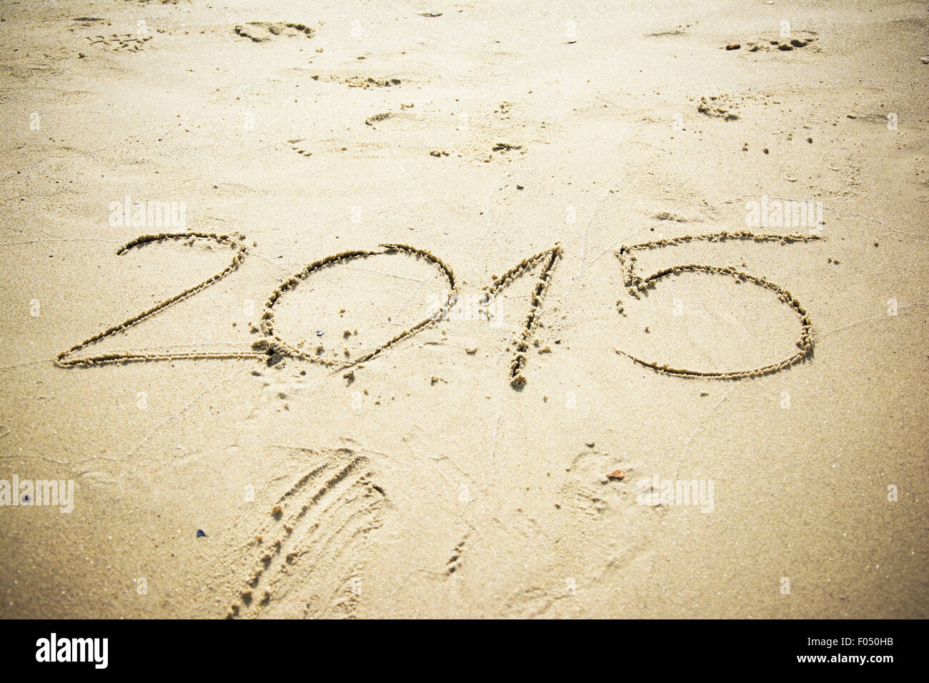 Numbers 2015 written on sandy beach at sunset meaning closing the old ...