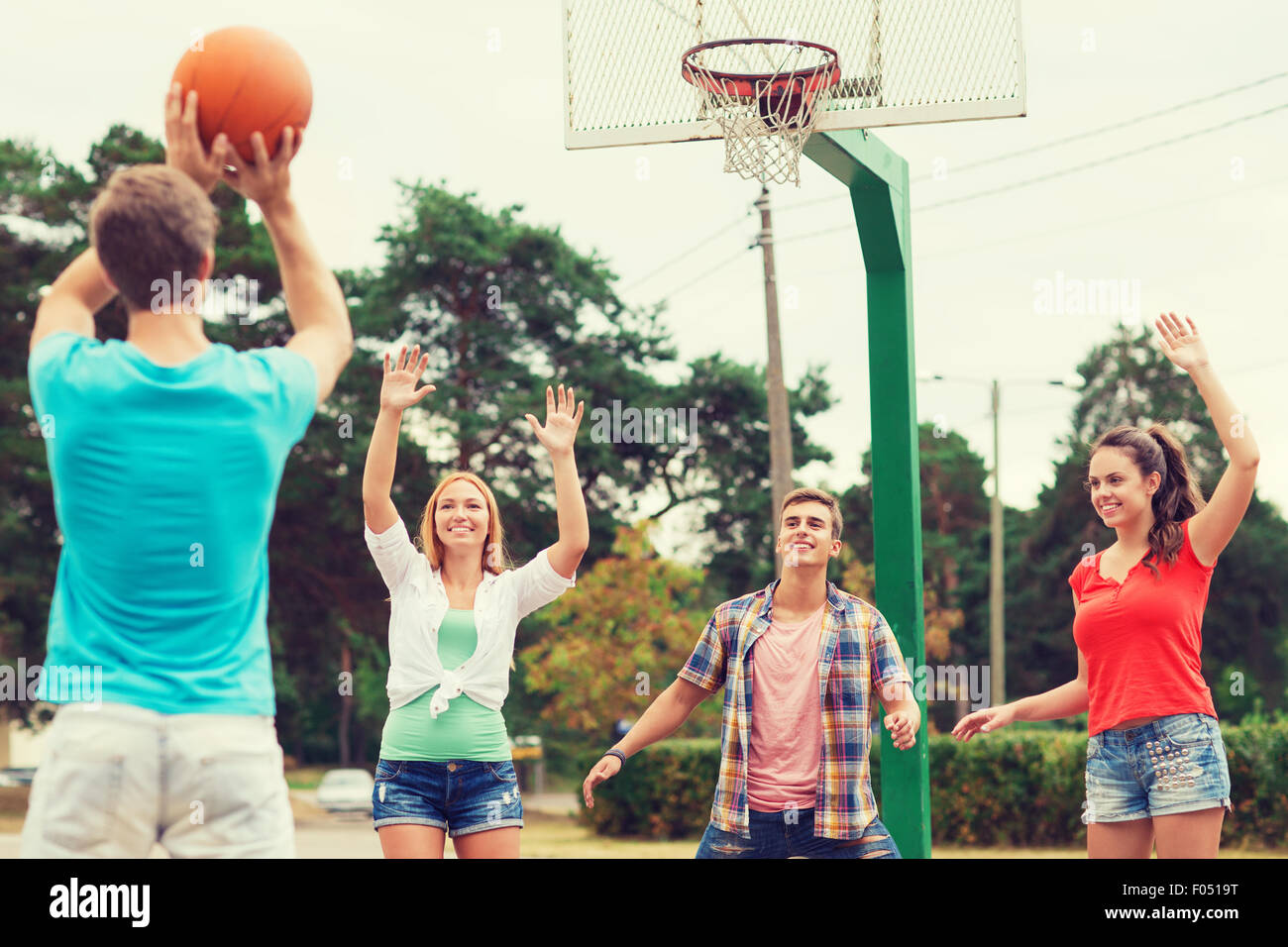 group of smiling teenagers playing basketball Stock Photo - Alamy